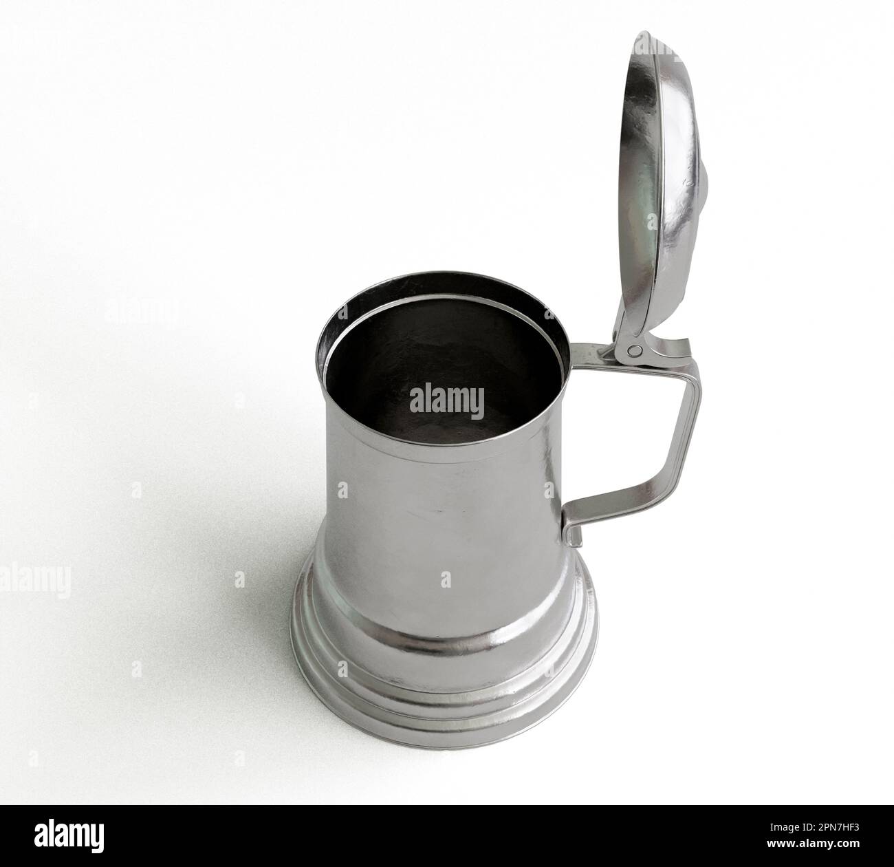 A vintage silver drinking tankard with a lid on an isolated white ...