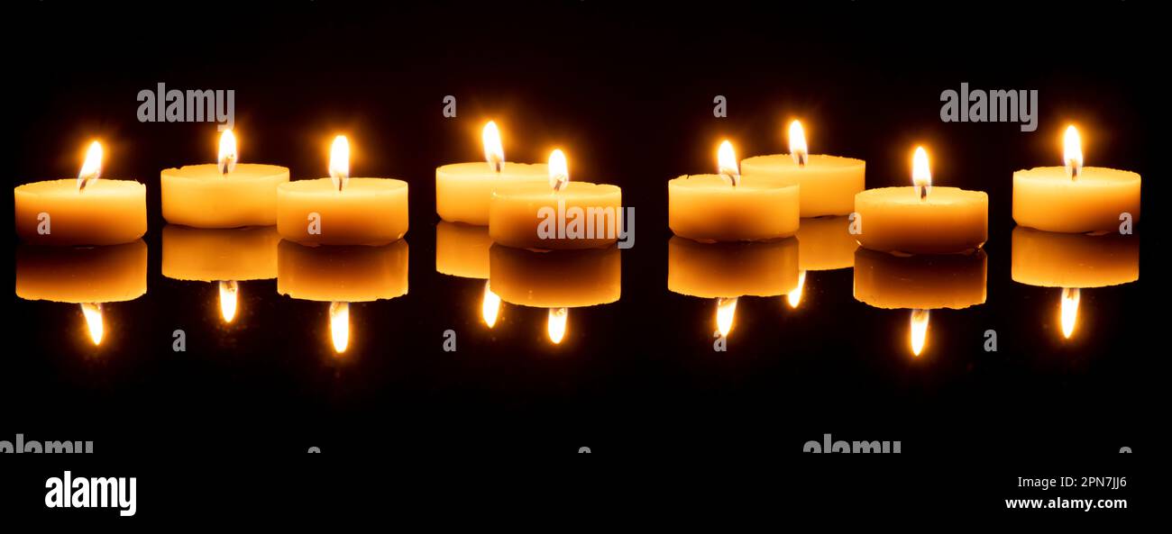 some tee candles on a black acrylic background for banner, panorama or ...