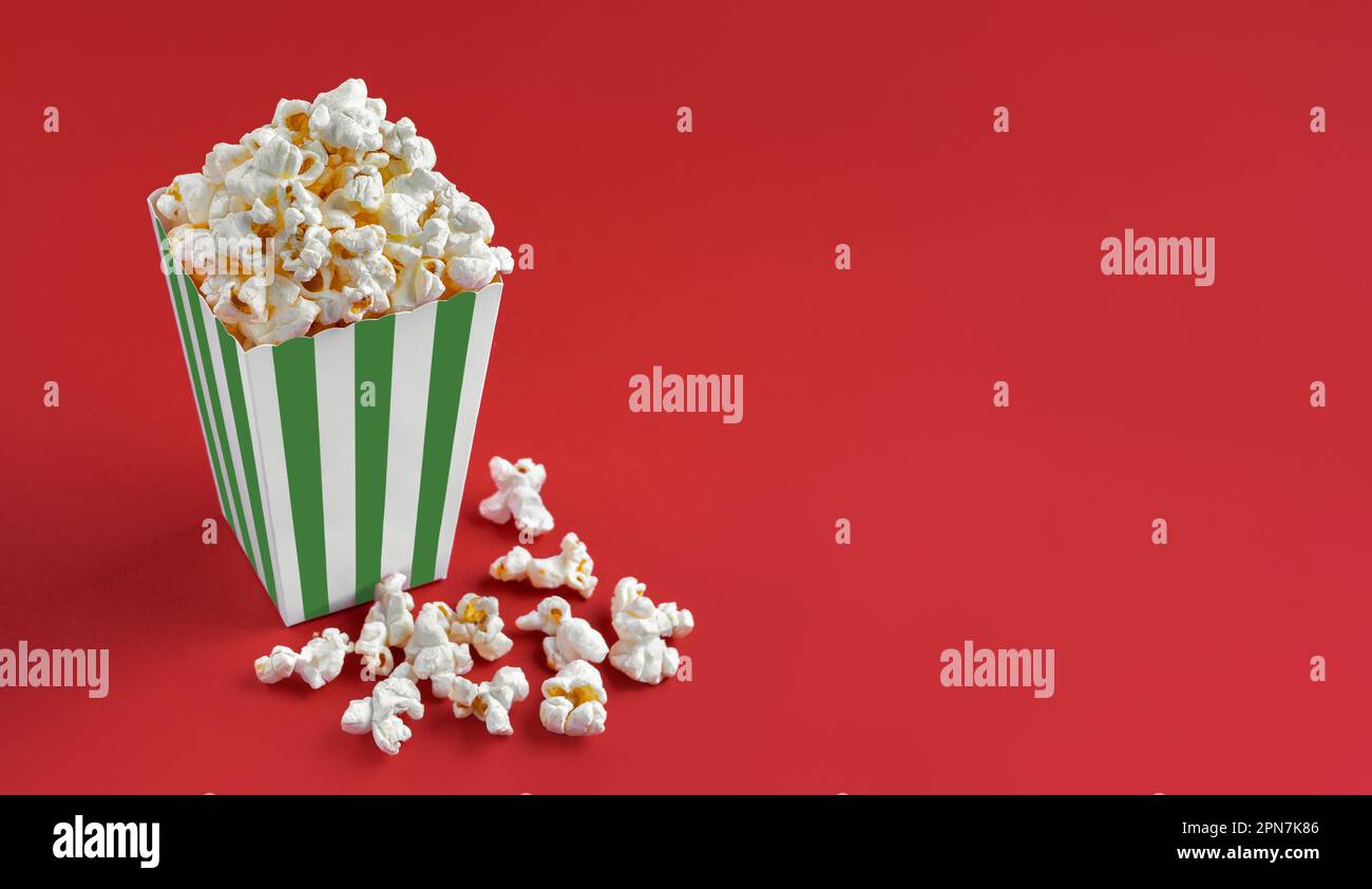 Green white striped carton bucket with tasty cheese popcorn, isolated ...