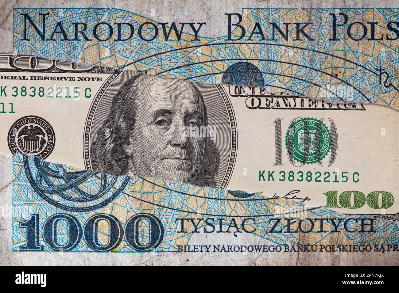 100 dollar banknote through torn 1000 Polish zloty banknote for design ...