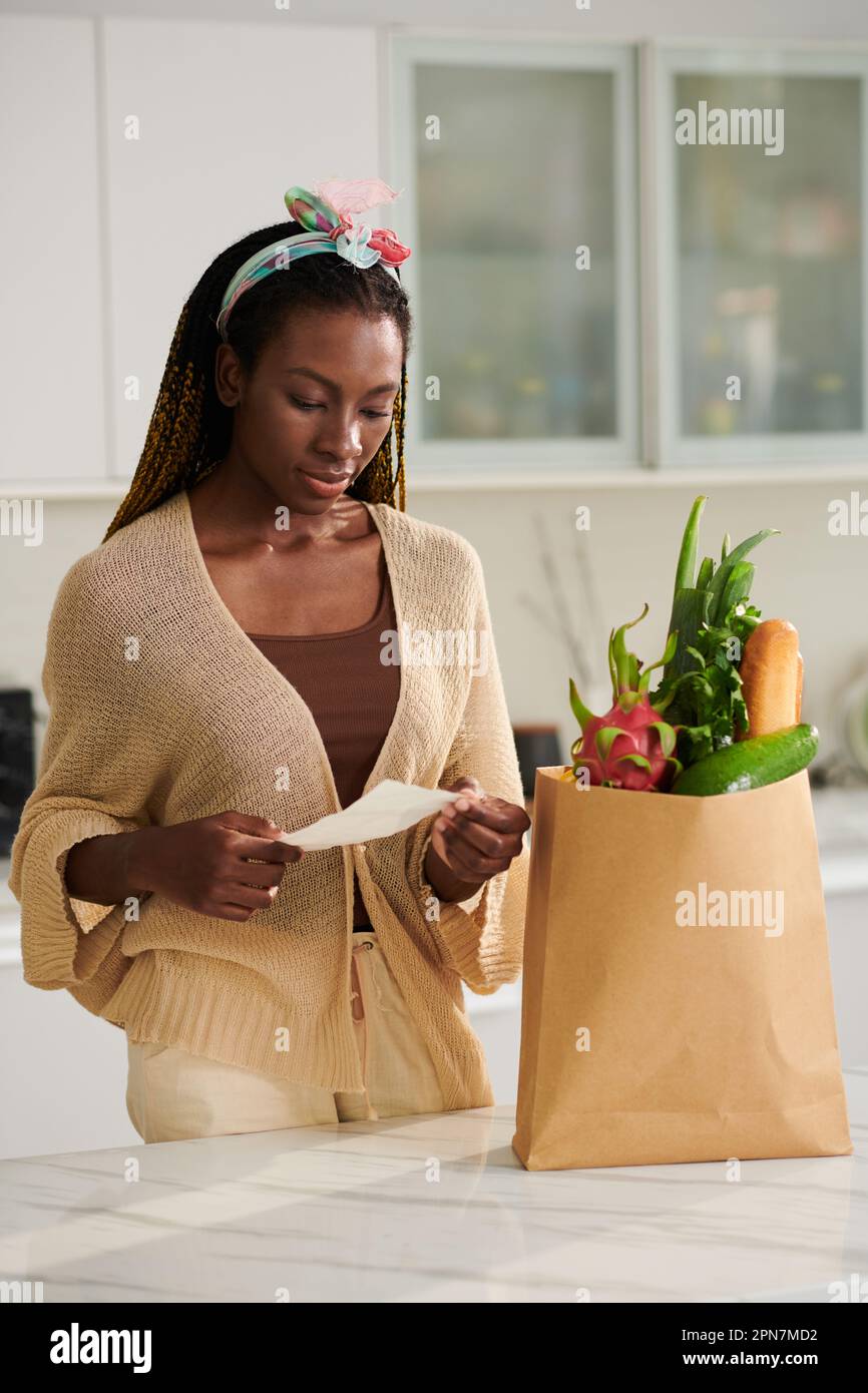 Black woman checking receipt after receviving food delivery Stock Photo ...