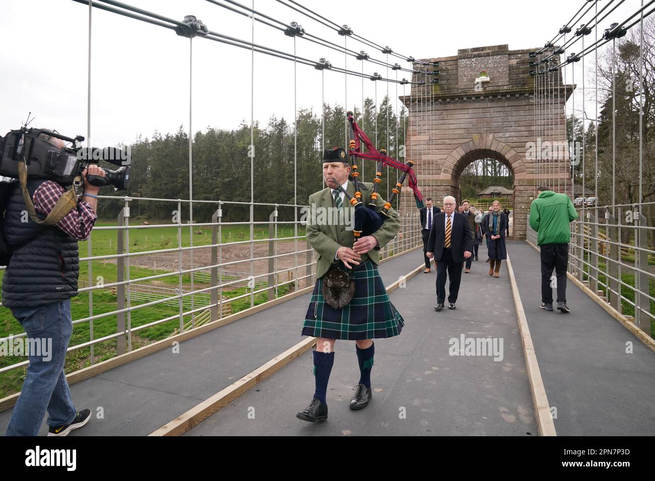 A piper leads people across the Union Chain Bridge, spanning from the ...
