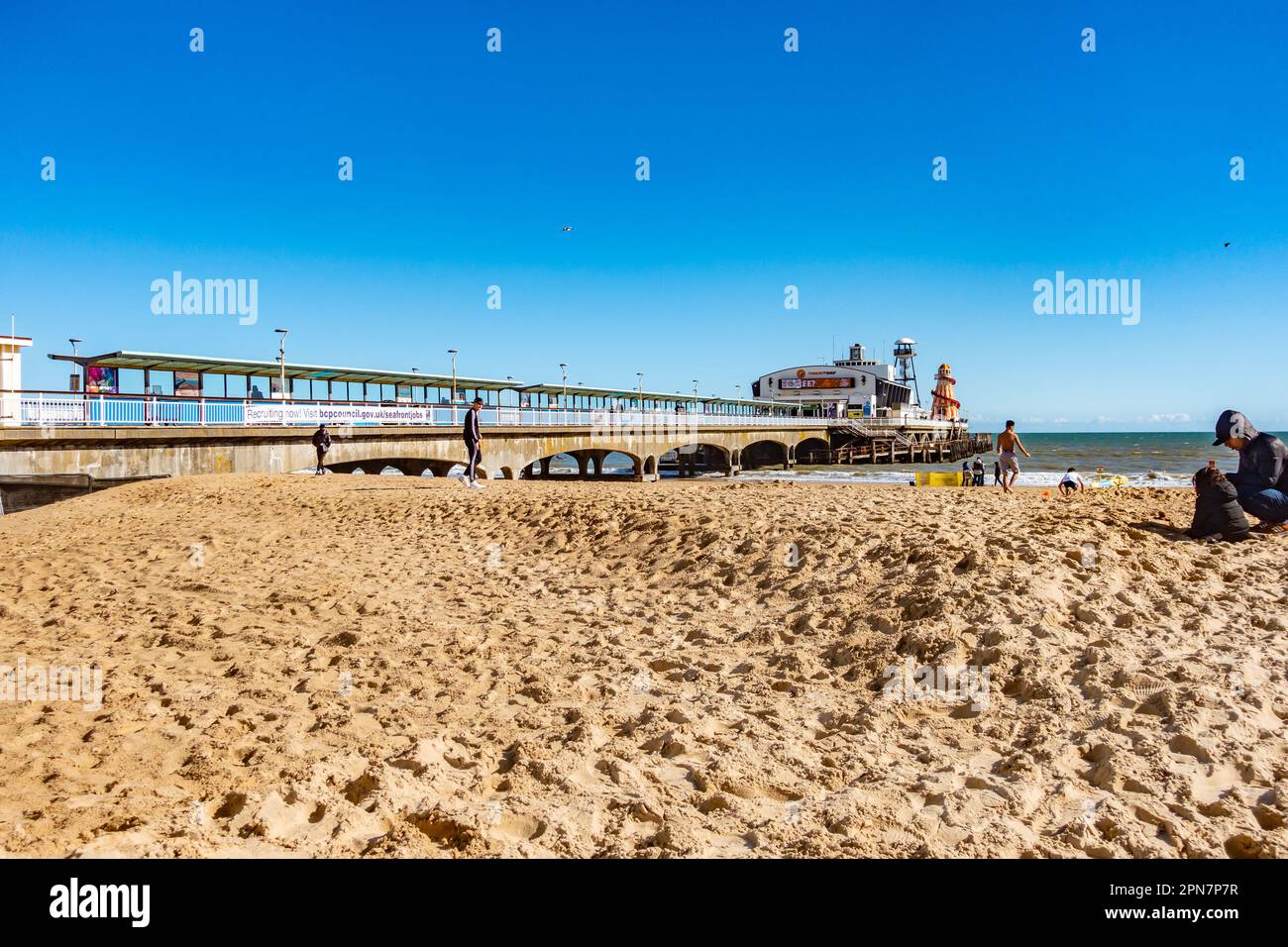 Bournemouth Pier in Dorset, UK seen in April so he beach is relatively ...