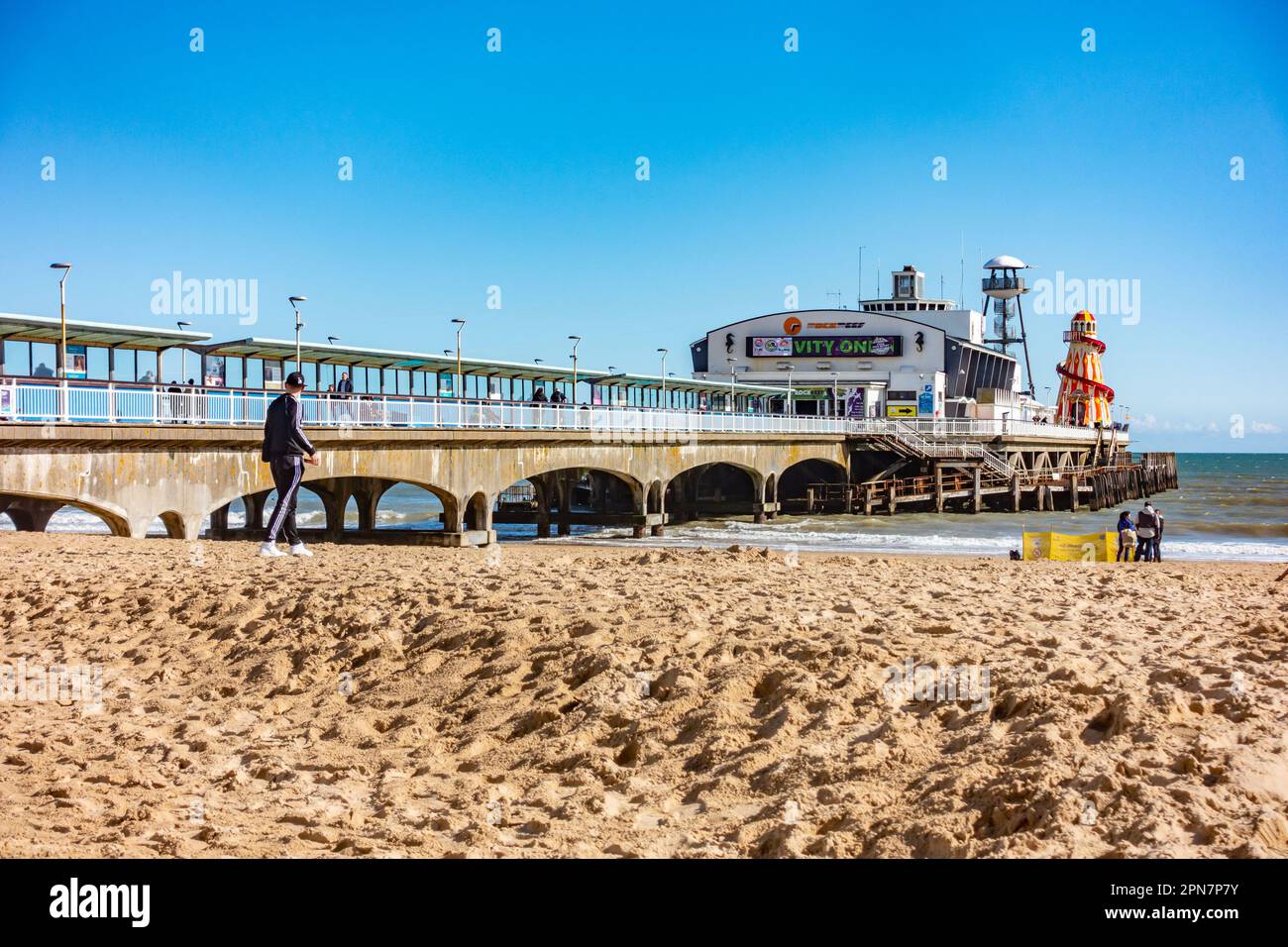 Bournemouth Pier in Dorset, UK seen in April so he beach is relatively ...