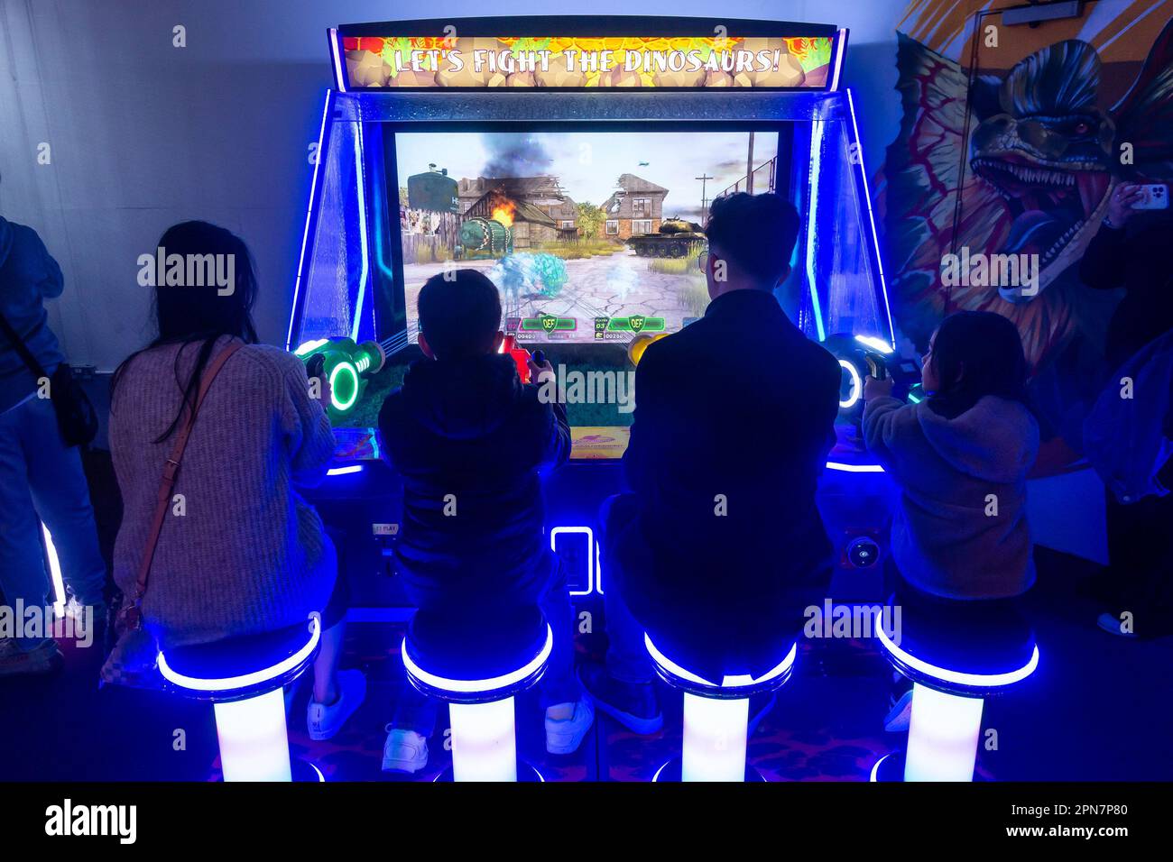Friends play an arcade game together at an amusements arcade in ...