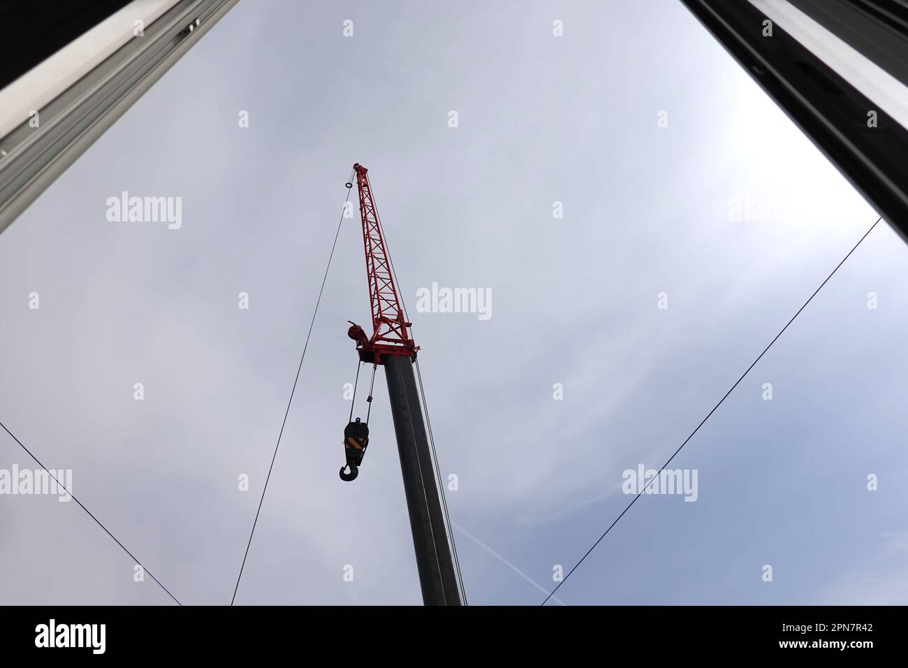 Big construction arm crane with heavy hook on metal cable view from ...