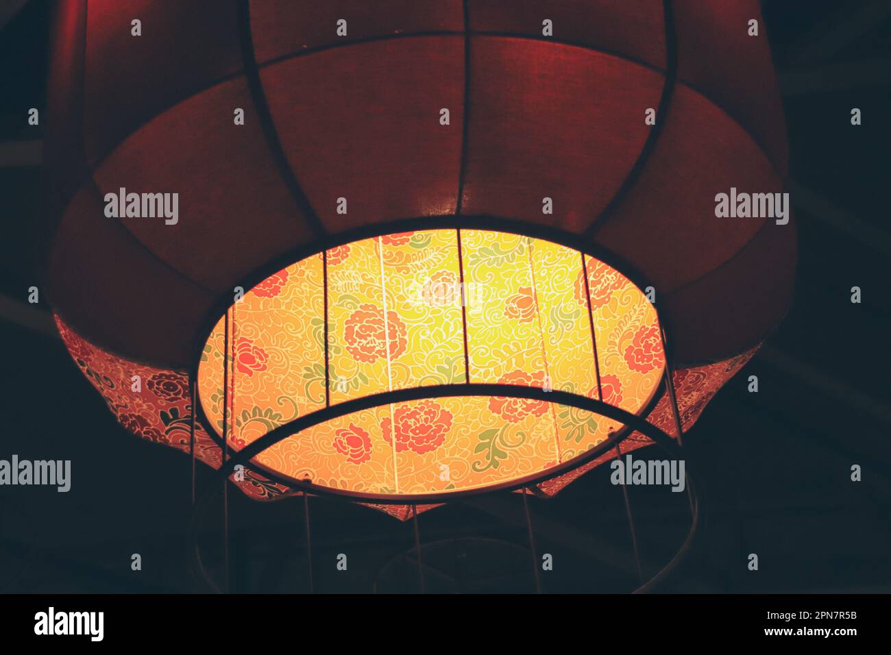 A Chinese lantern illuminates a dark room, the light from the lantern ...