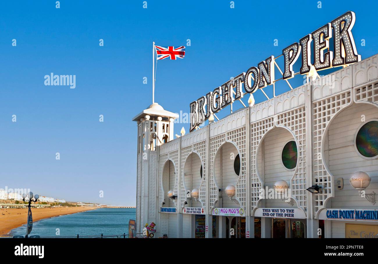 Brighton Pier, retro sign sea sun and sandy beach with Union Jack flag ...