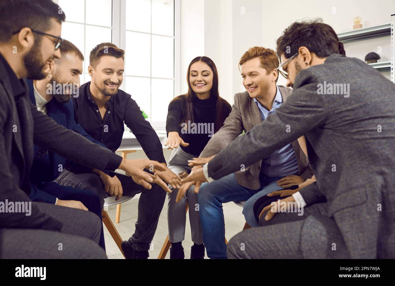 Beautiful men and women join hands in circle as symbol of cooperation ...