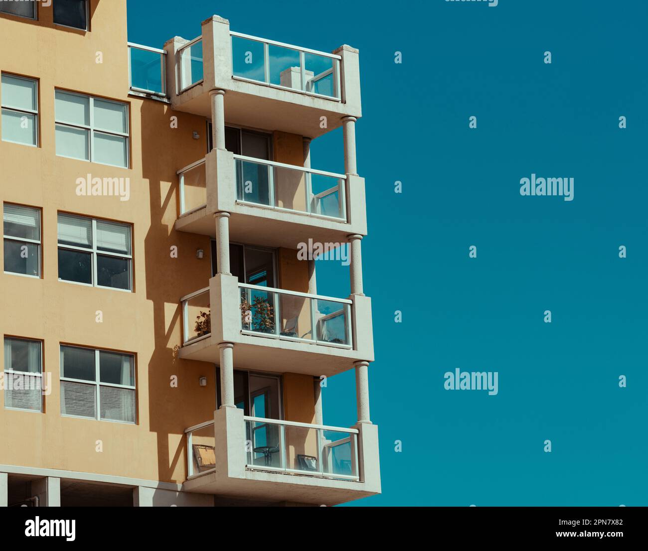 A high-rise structure with multiple balconies against a blue sky ...
