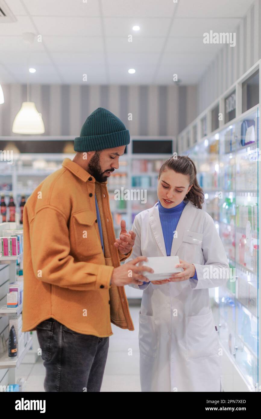 Professional pharmacist helping female customer hi-res stock ...