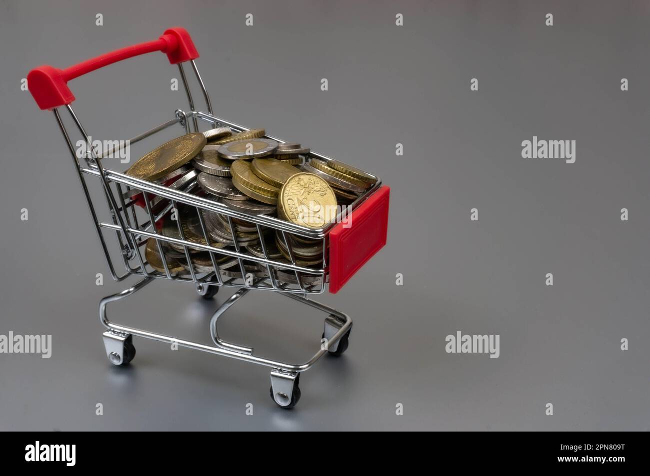 A supermarket cart full of coins. It symbolizes finance, investment ...