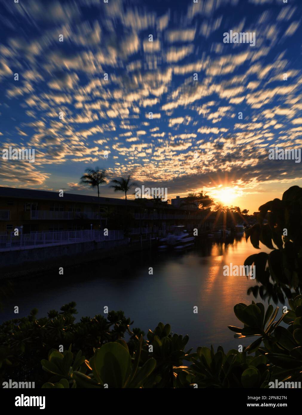 A stunning sunset view of a river and shoreline, with wispy clouds ...