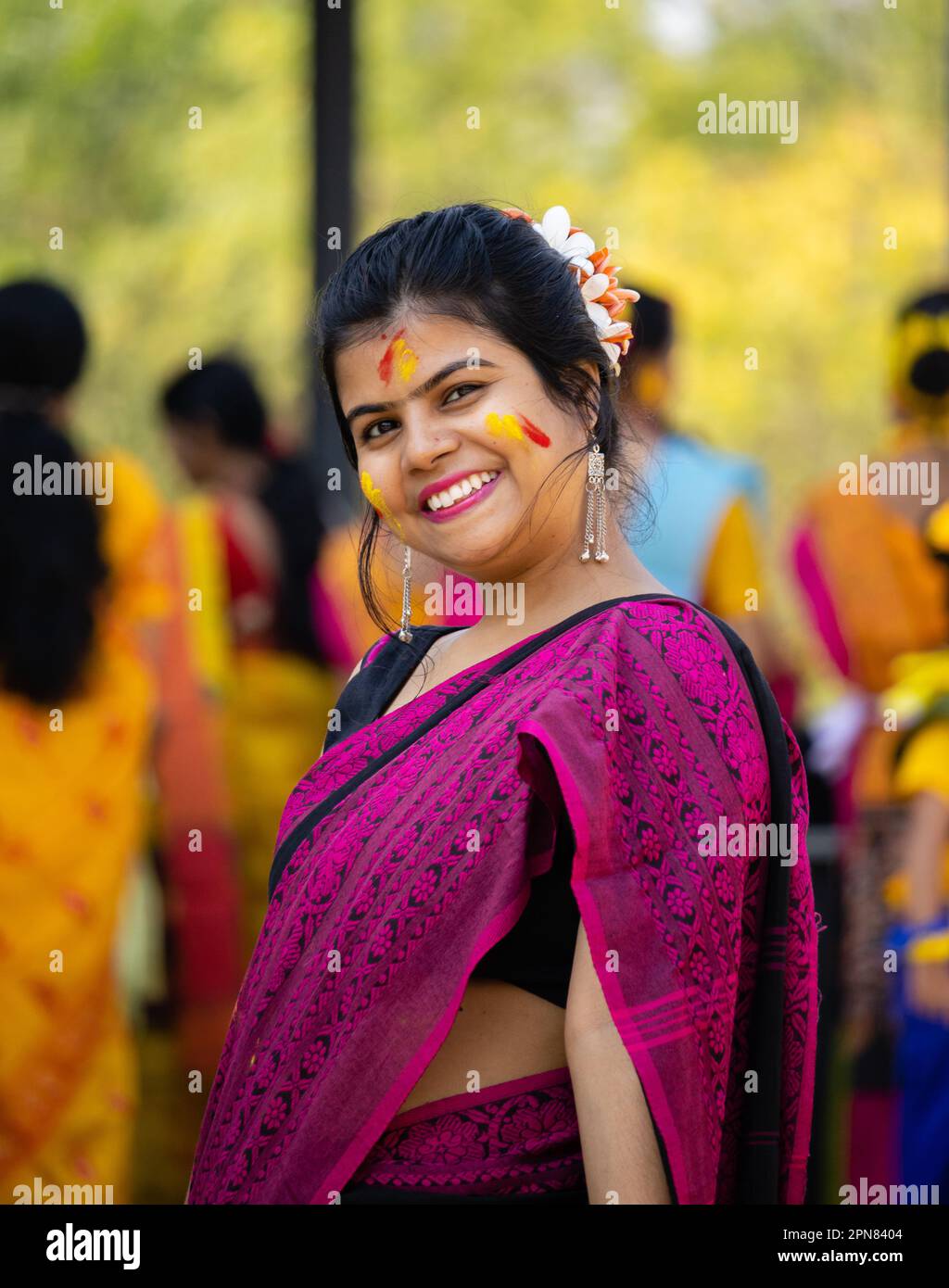 An Indian woman with colorful face looking at camera in holi - the ...