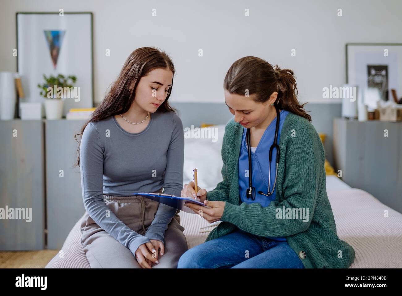 Teenage Girl Having Stomach Ache Young Doctor Examining Her Stock