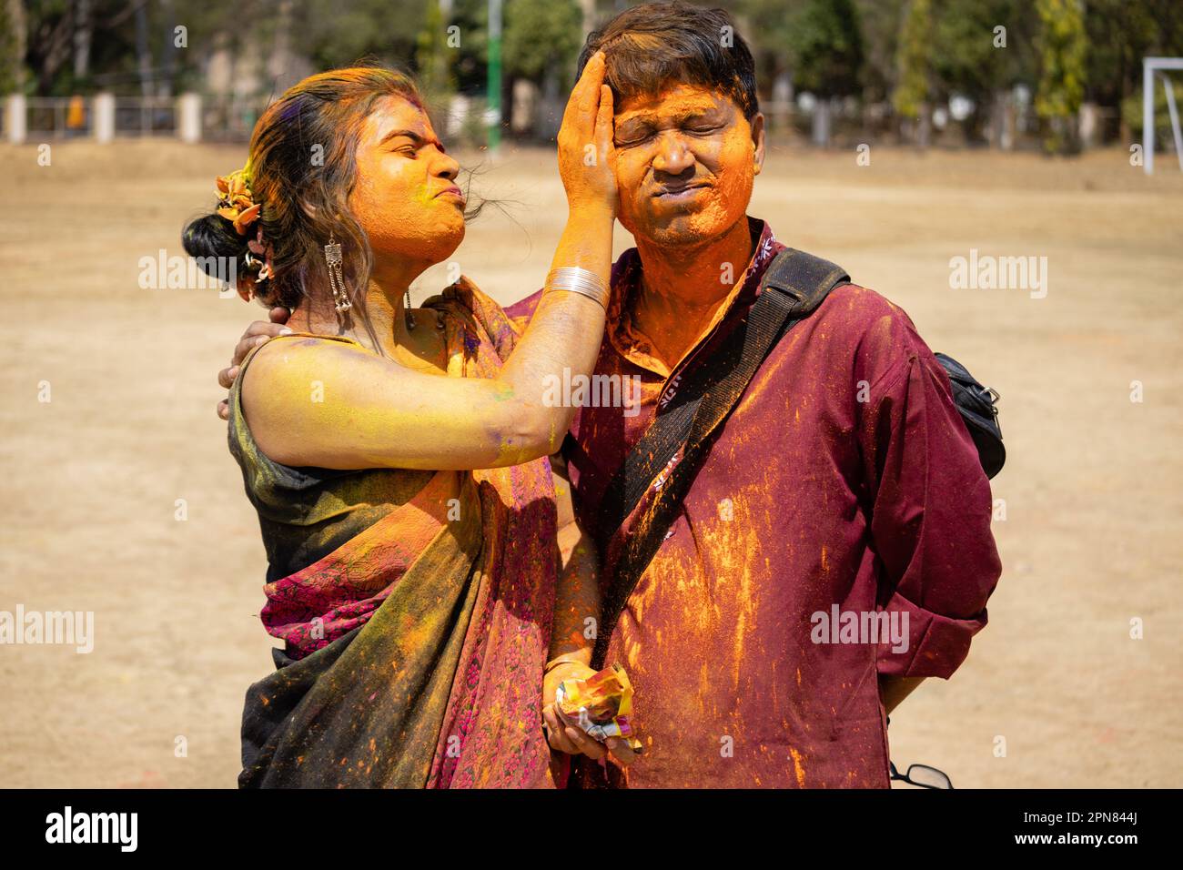 An Indian Bengali woman and man in traditional dress playing holi - the ...