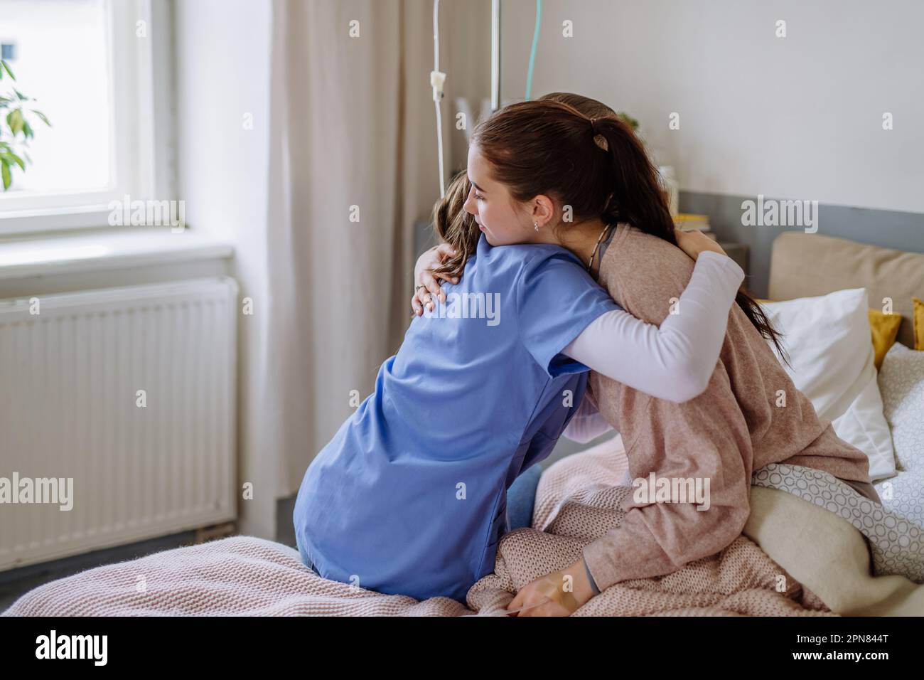 Young doctor hugging teenage girl in hospital room Stock Photo - Alamy