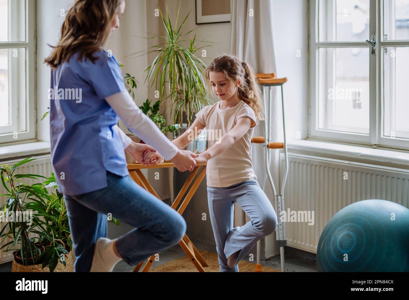Little girl doing exercise with a nurse Stock Photo - Alamy