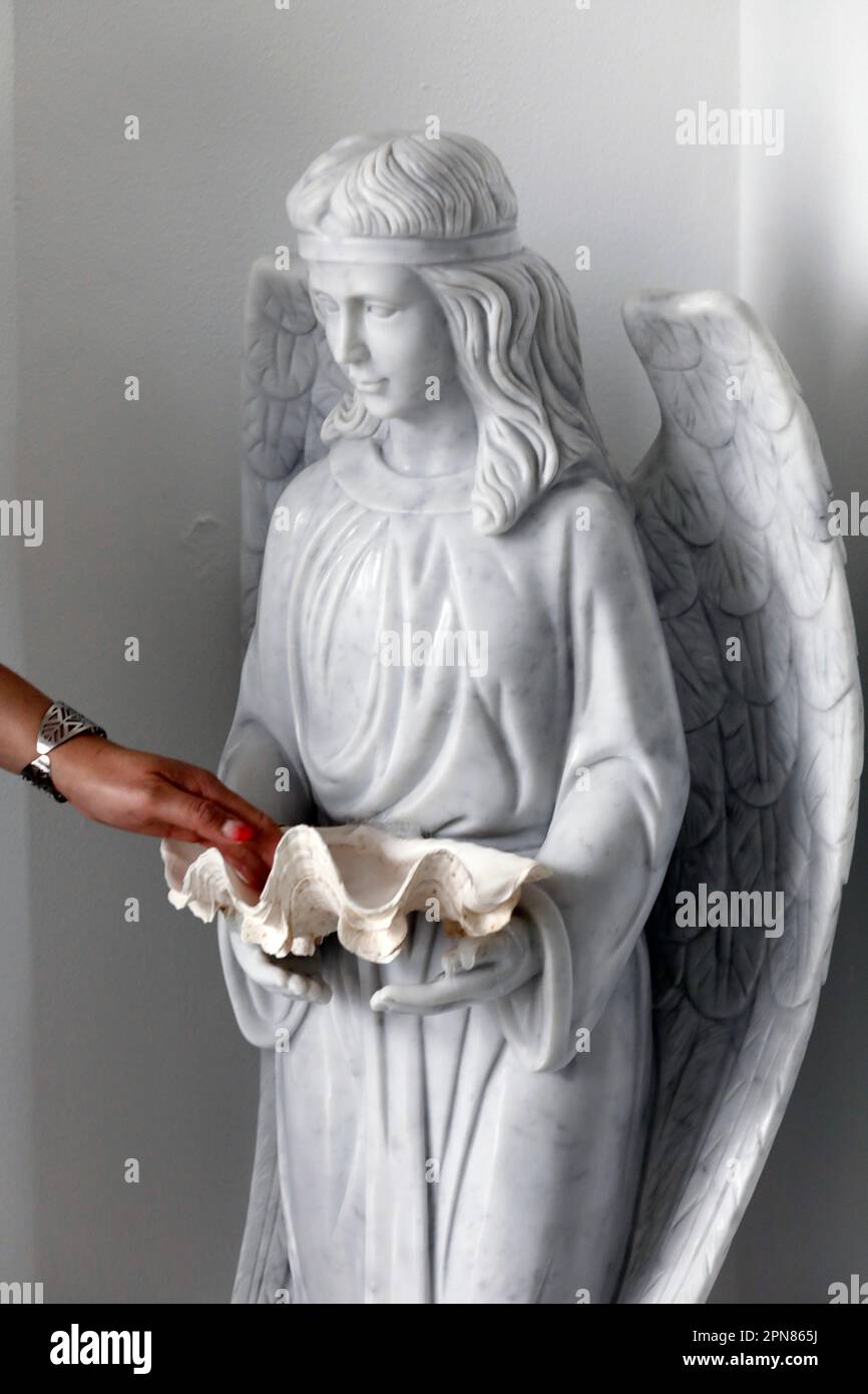 Church of Saints Peter and Paul. Hand of a woman and holy water font ...