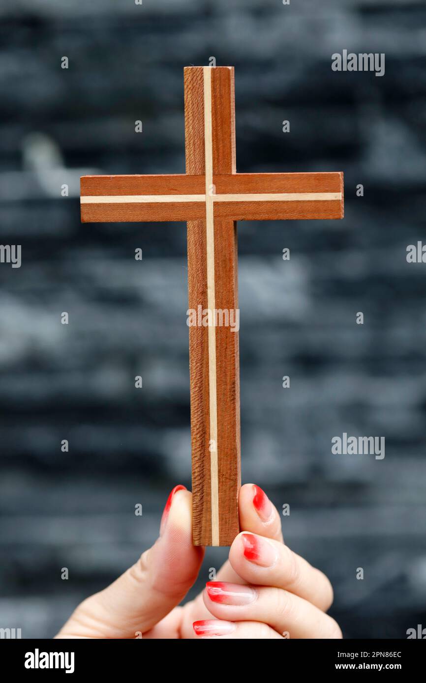 Woman praying to God, holding cross in hand. Faith and spirituality ...