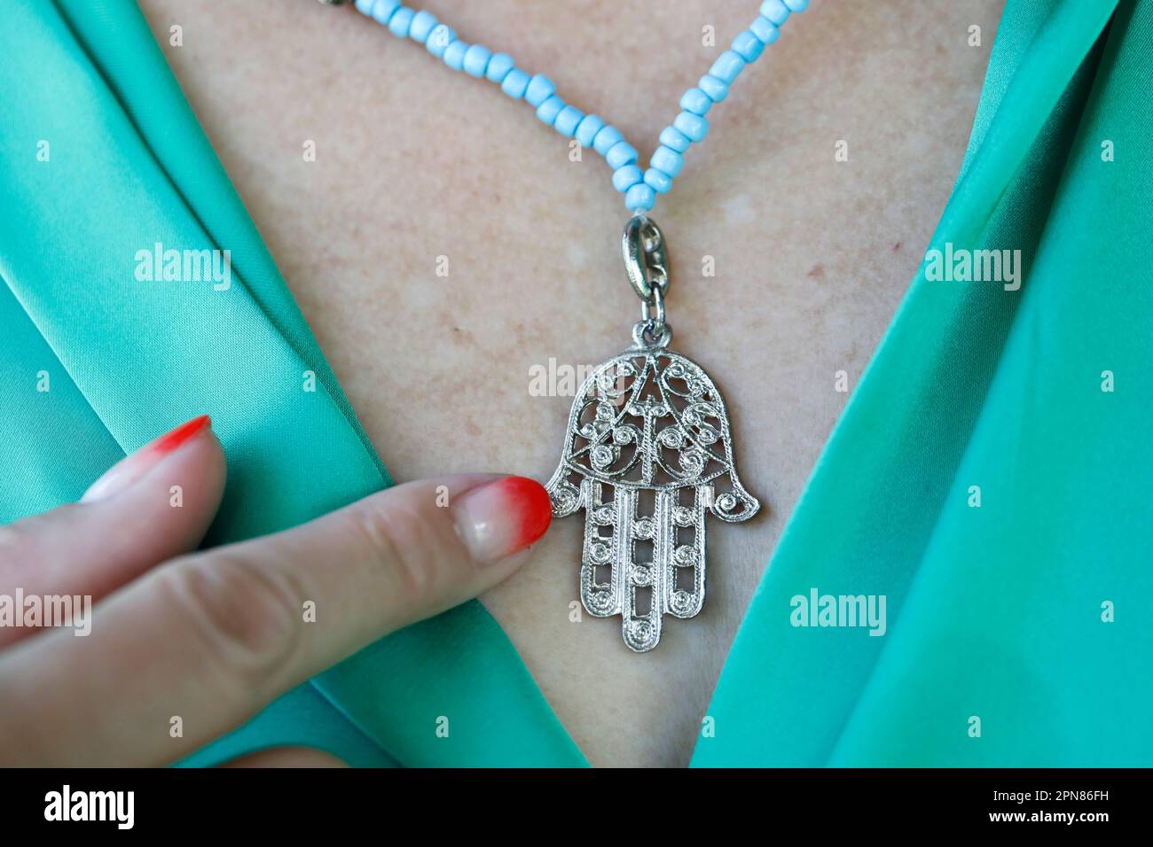 Woman wearing a muslim hamsa amulet, also known of the hand of fatima ...