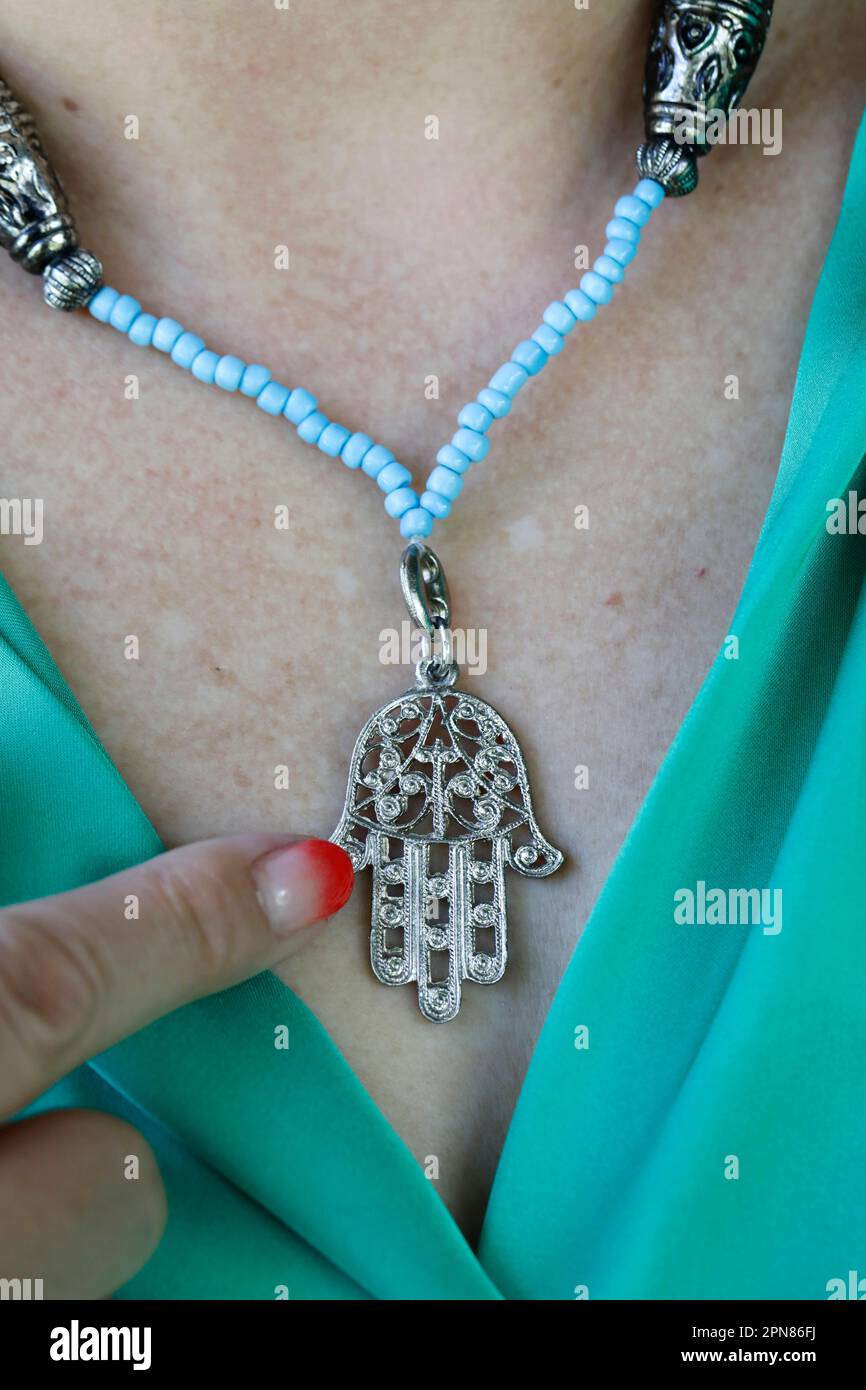 Woman wearing a muslim hamsa amulet, also known of the hand of fatima ...