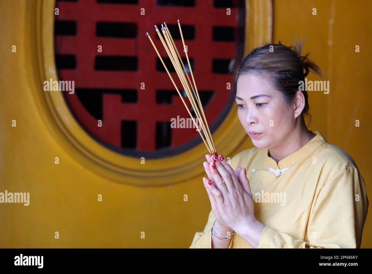 Rong Thanh Temple. Buddhist woman praying with incense sticks. Faith ...