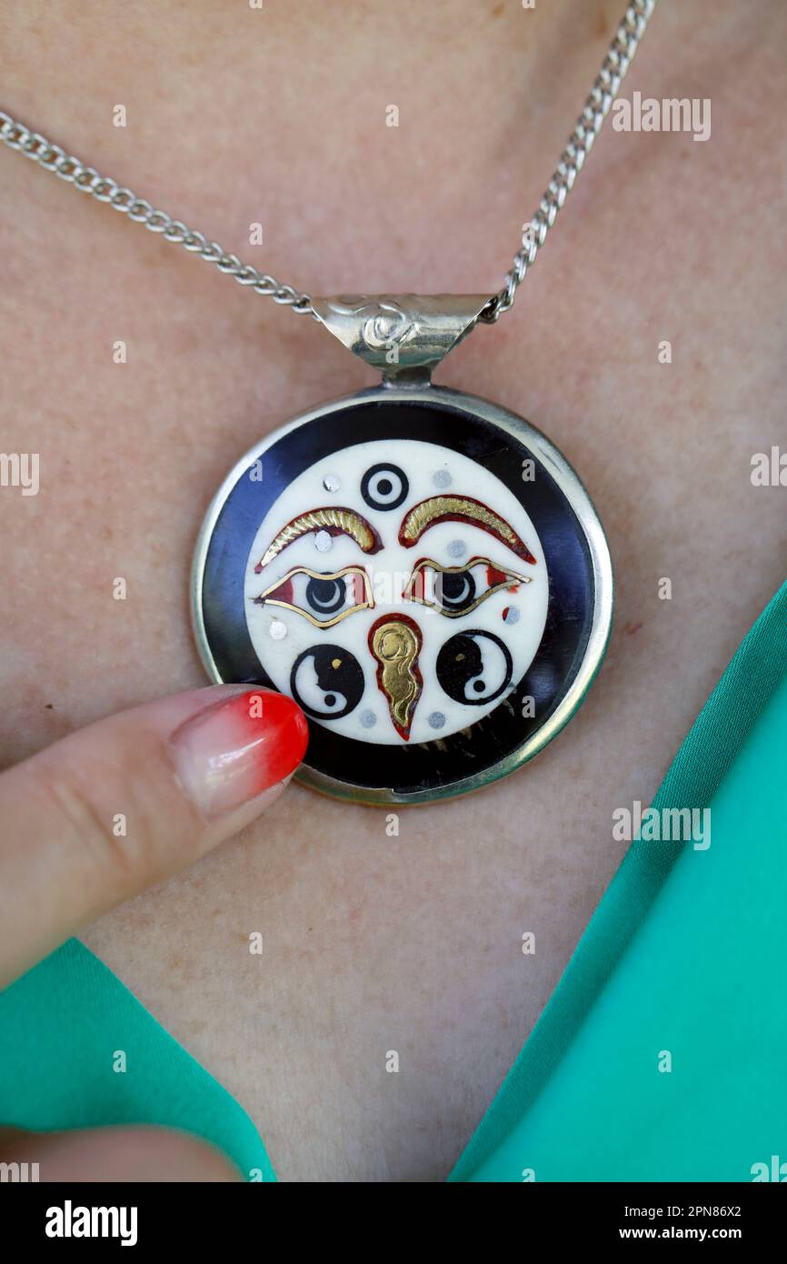 Woman with Tibetan brass and silver eye of buddha mantra pendant ...