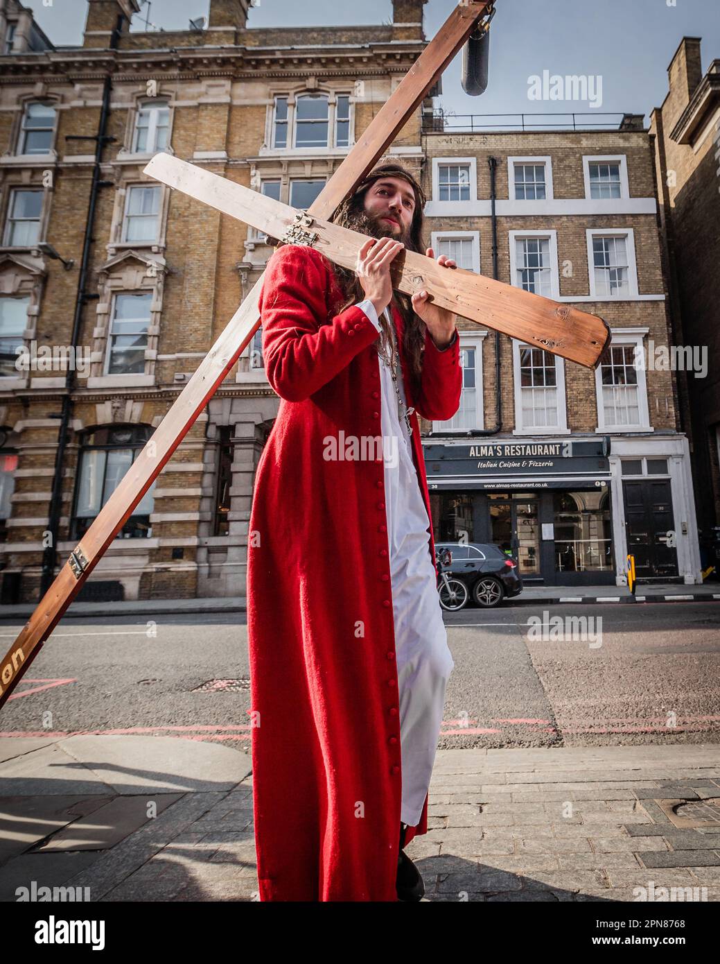 An acting Jesus Christ carries the cross on the streets of London on ...