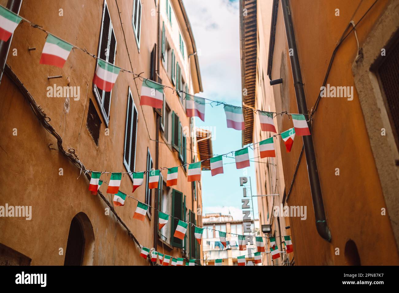 Italian flags and pennants in an old town narrow street of a city in ...
