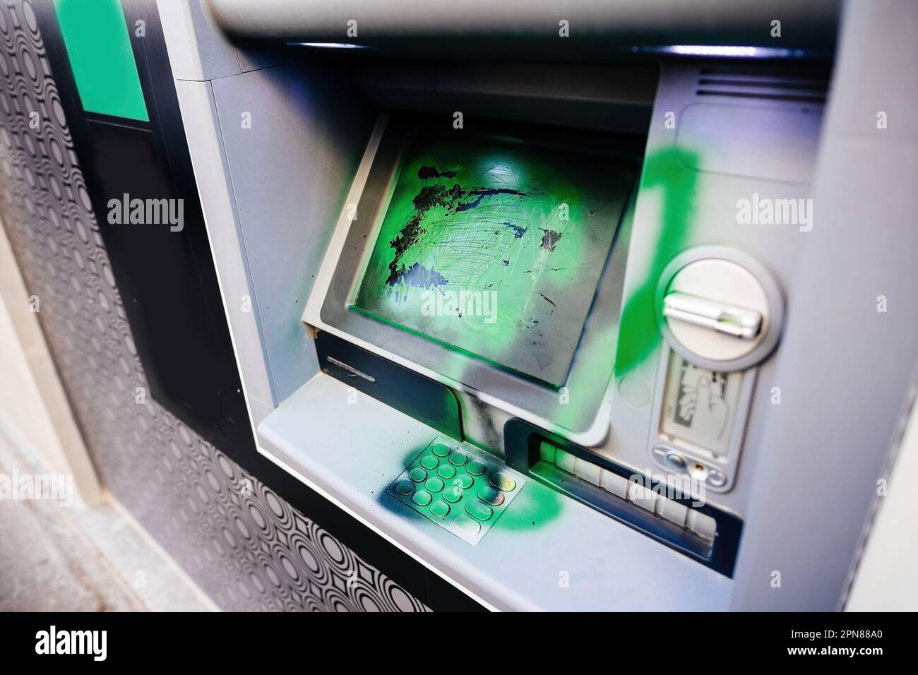 Graffiti-covered ATM in a European city, the aftermath of a protest ...