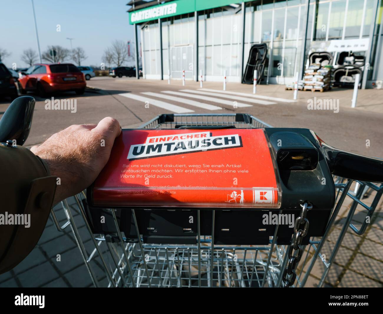 Frankfurt, Germany - Mar 4, 2023: A person pushes a red cart into ...