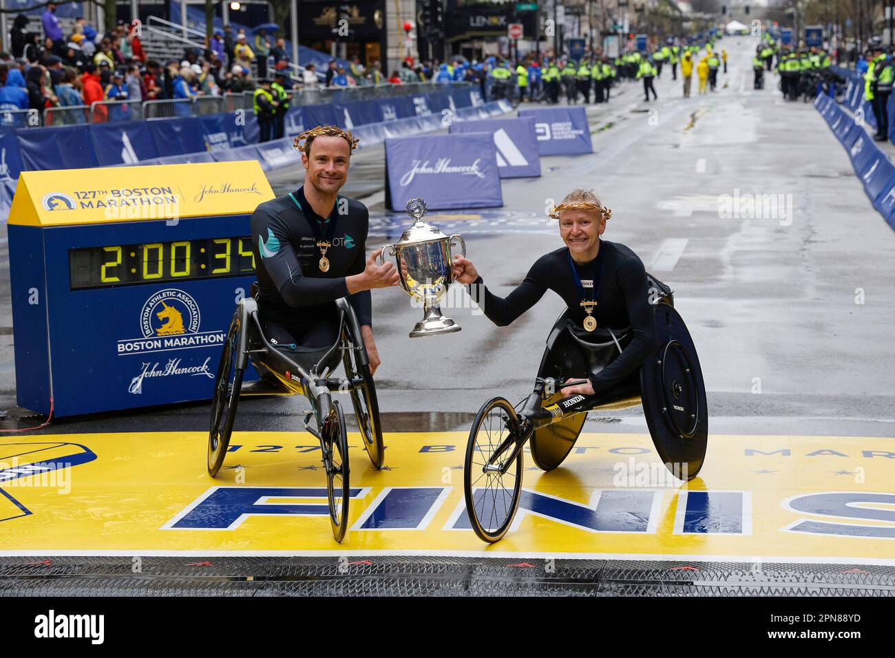 Marcel Hug of Switzerland, left, and Susannah Scaroni hold the trophy ...