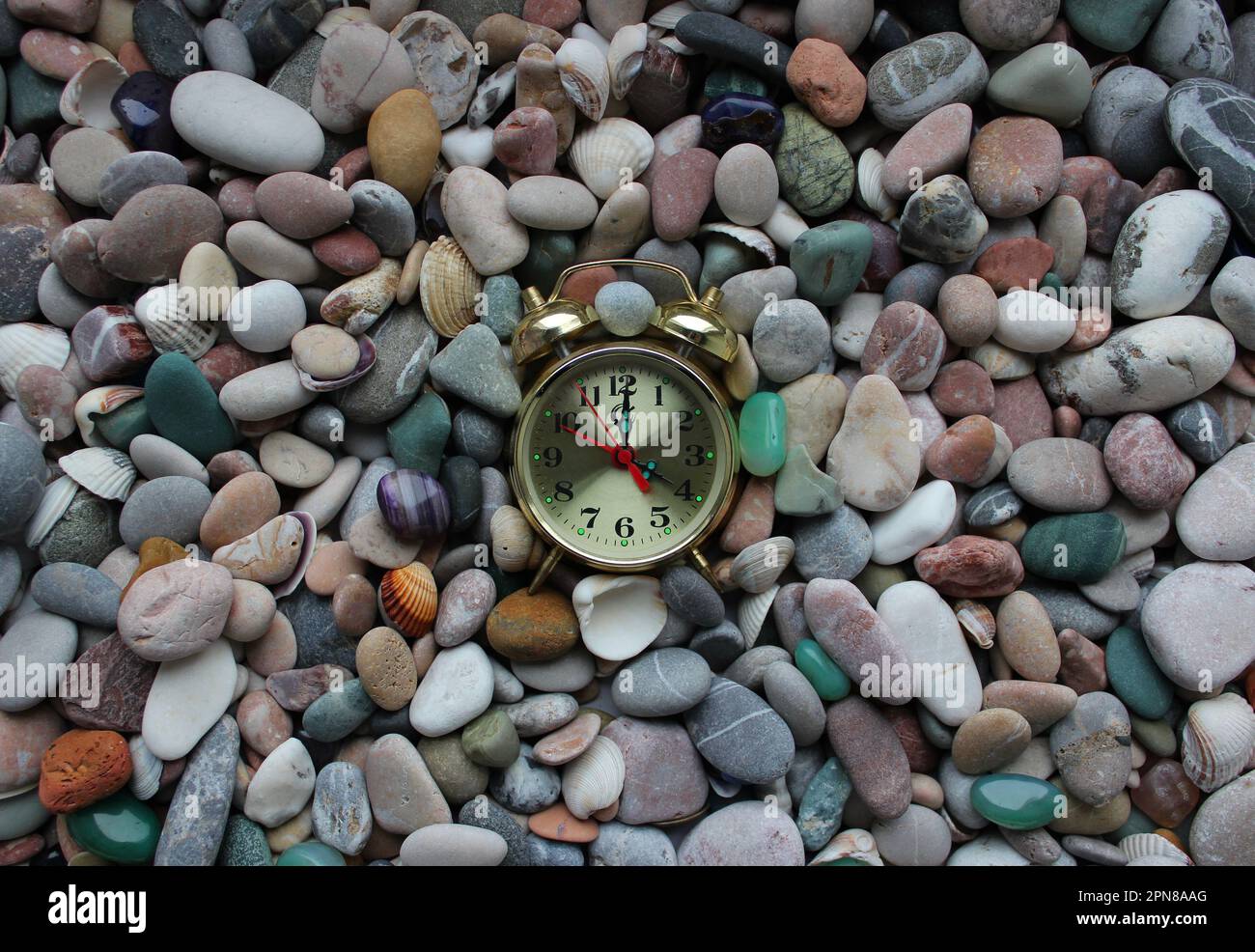 Vintage clock lies on a small sea pebbles and shells Stock Photo - Alamy