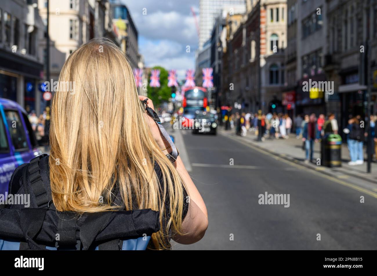 A young blonde photographer captures the energy and motion of busy ...