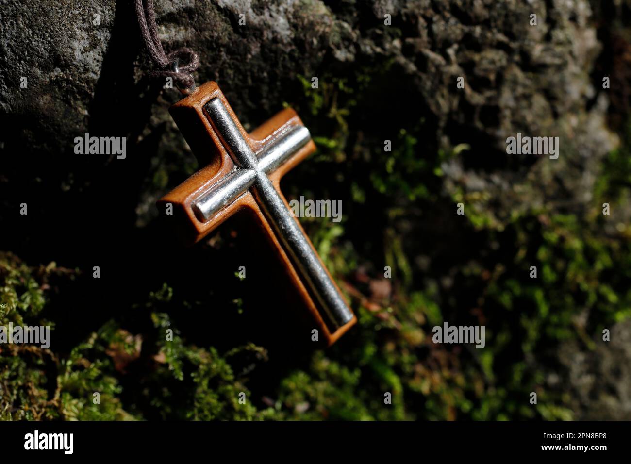 Christian cross on an old stone with moss. France Stock Photo - Alamy