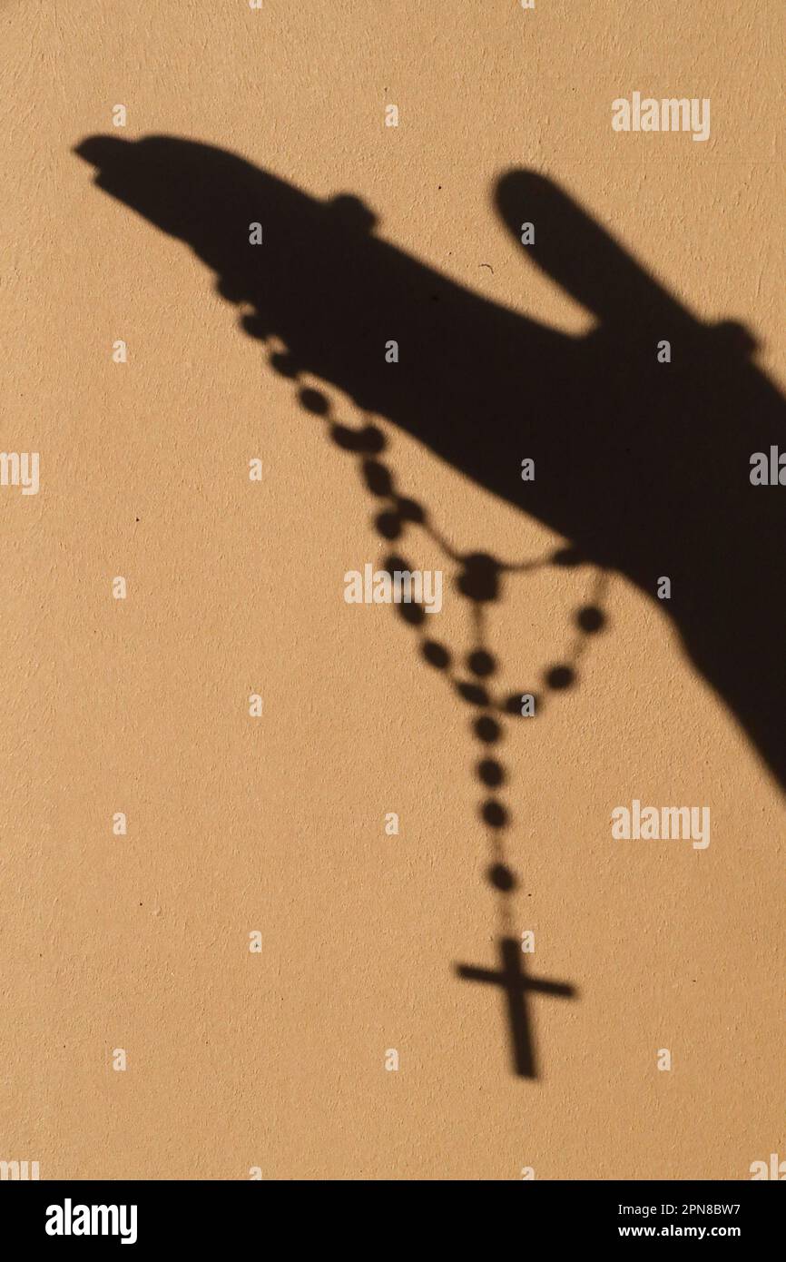 Shadow of a christian woman praying the Rosary. Close-up Stock Photo ...