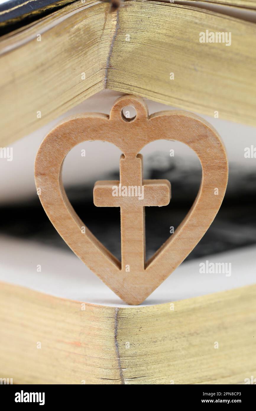 Bible with wooden heart with christian cross. Love and religion concept ...