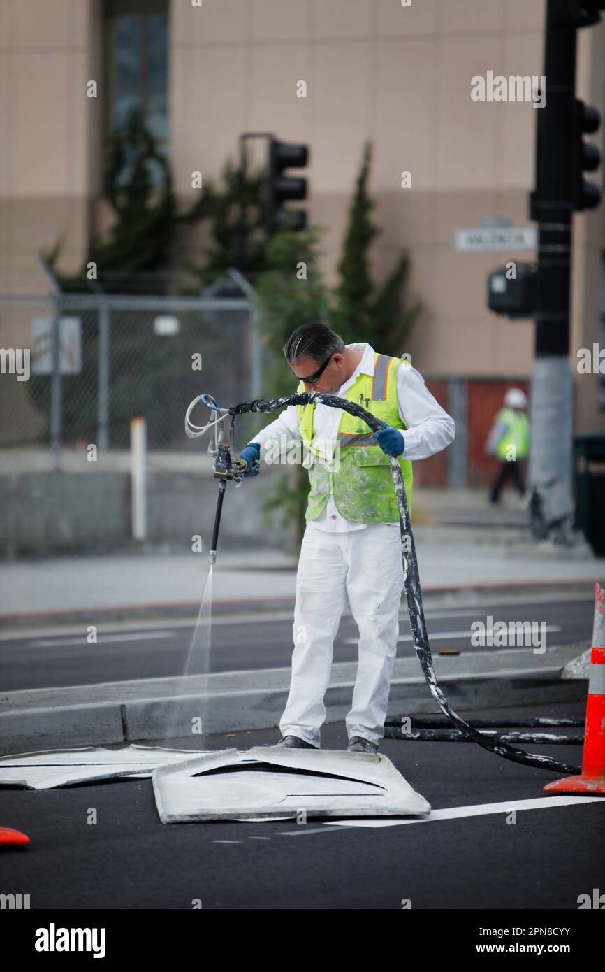 Laurent Grenacher, SFMTA painter, uses a stencil to paint a left left ...