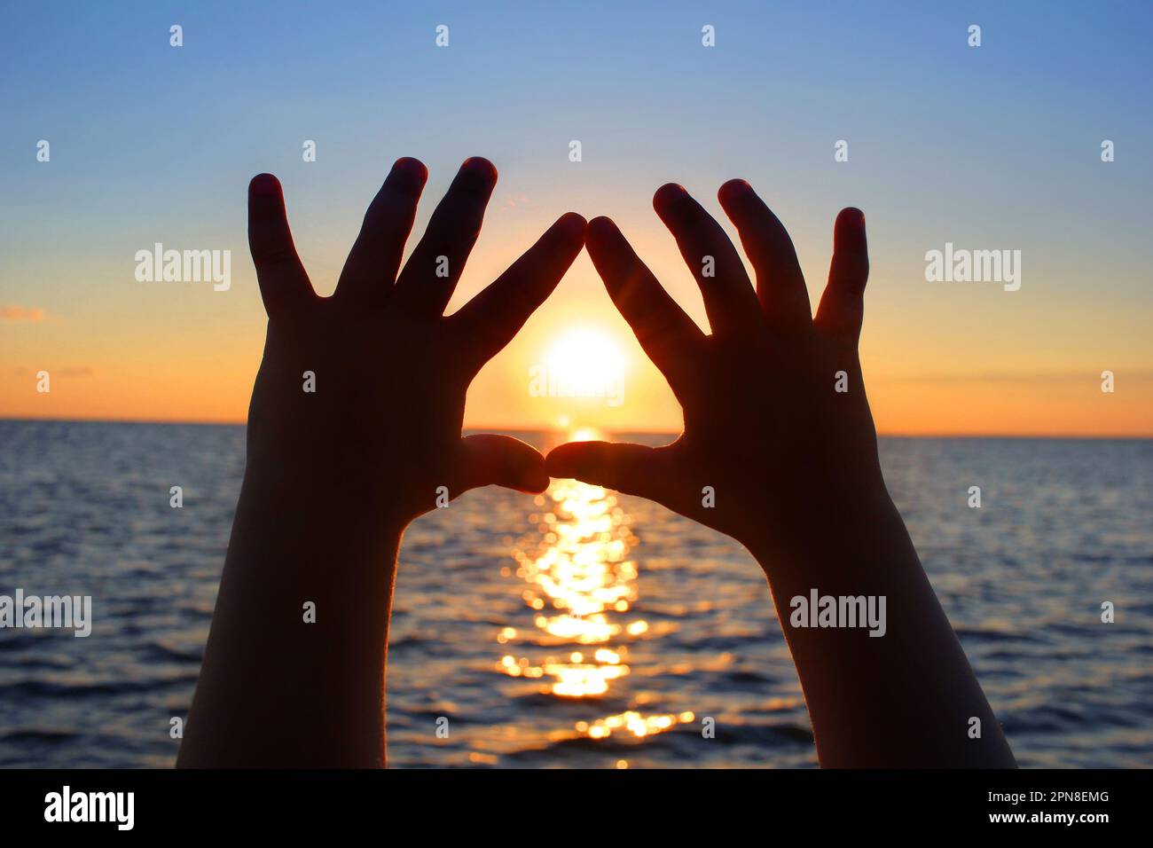 Baby hands on sunset background Stock Photo - Alamy