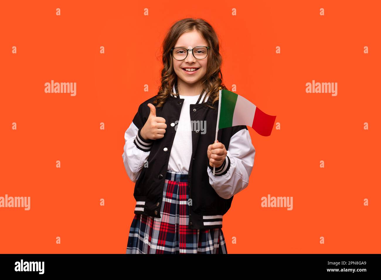 Girl wearing in school outfit and holds small national flag of Italy ...