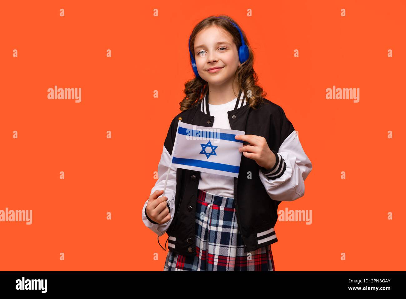 Teen school girl in casual clothes and headphones holds small flag of ...