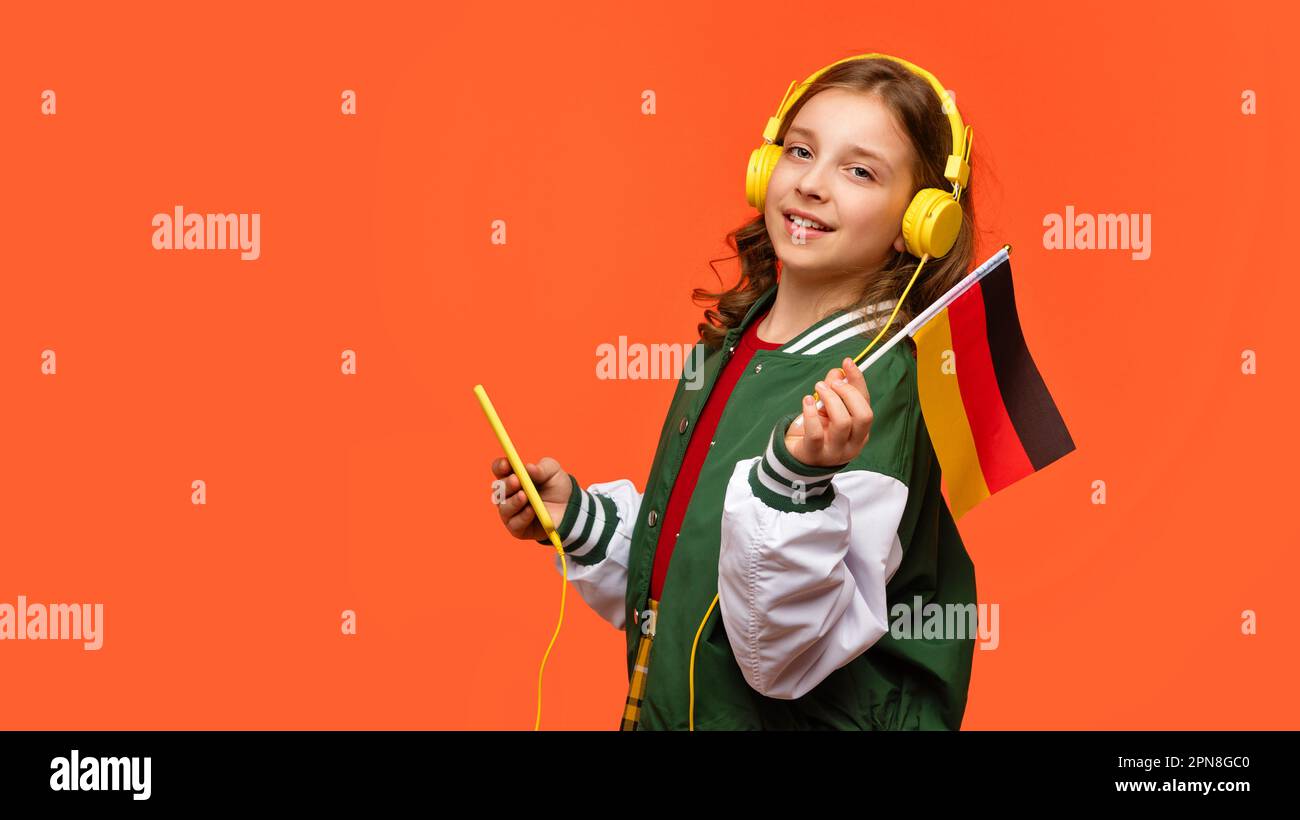 Teen school girl in casual clothes and headphones holds small national ...