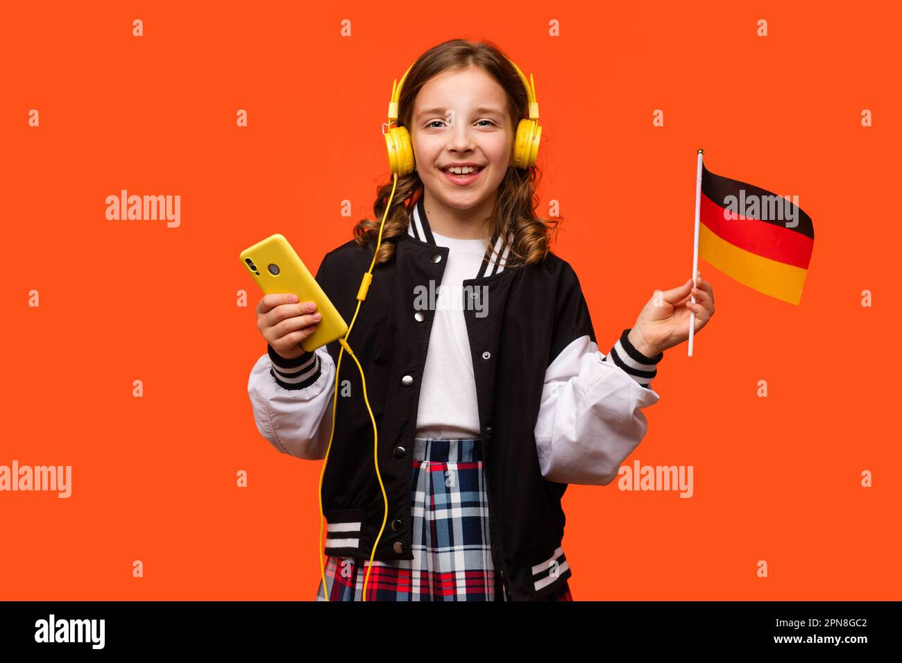 Teen school girl in casual clothes and headphones holds small national ...