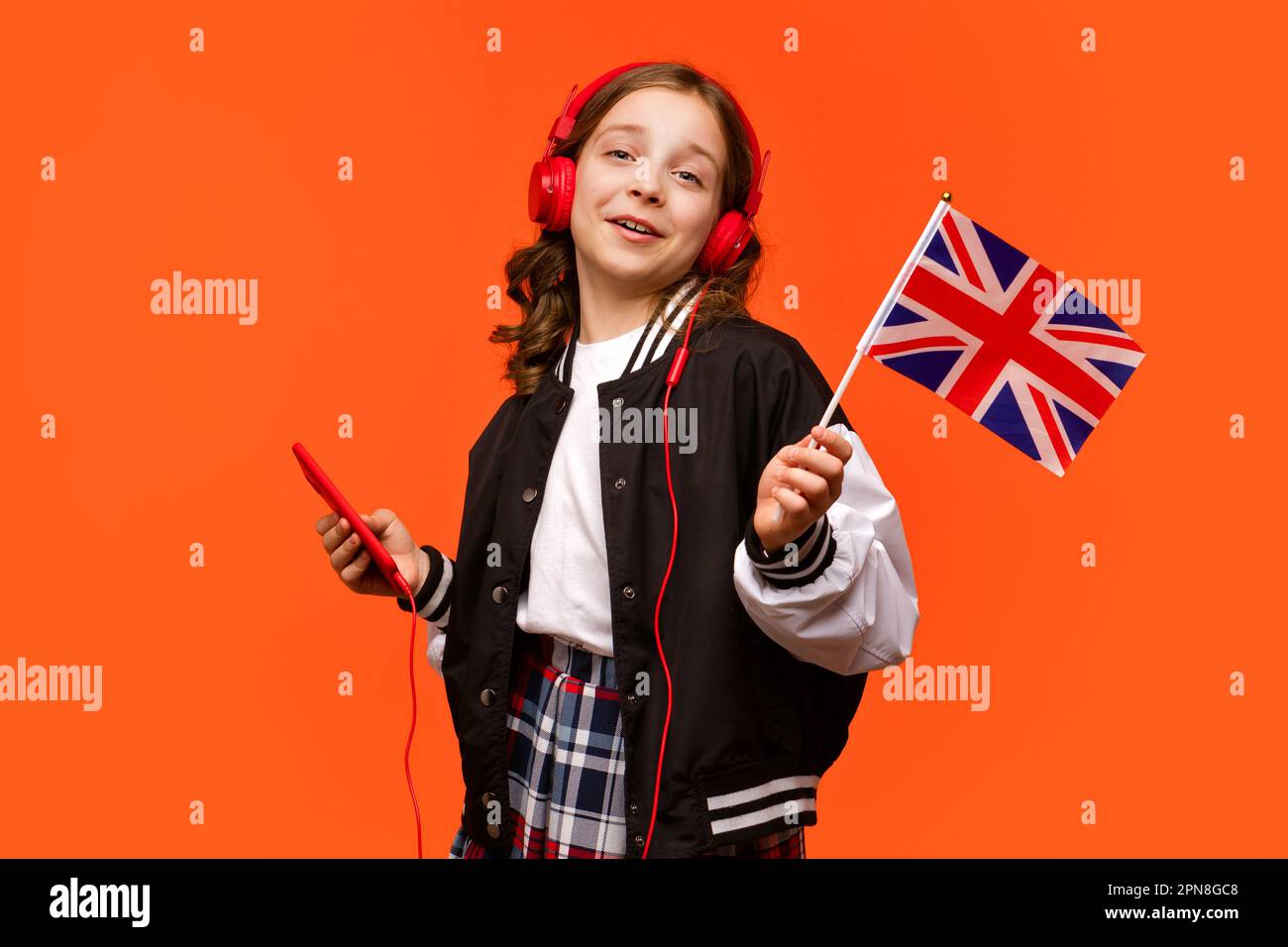 School girl holds small UK flag. Teen in casual clothes and red ...