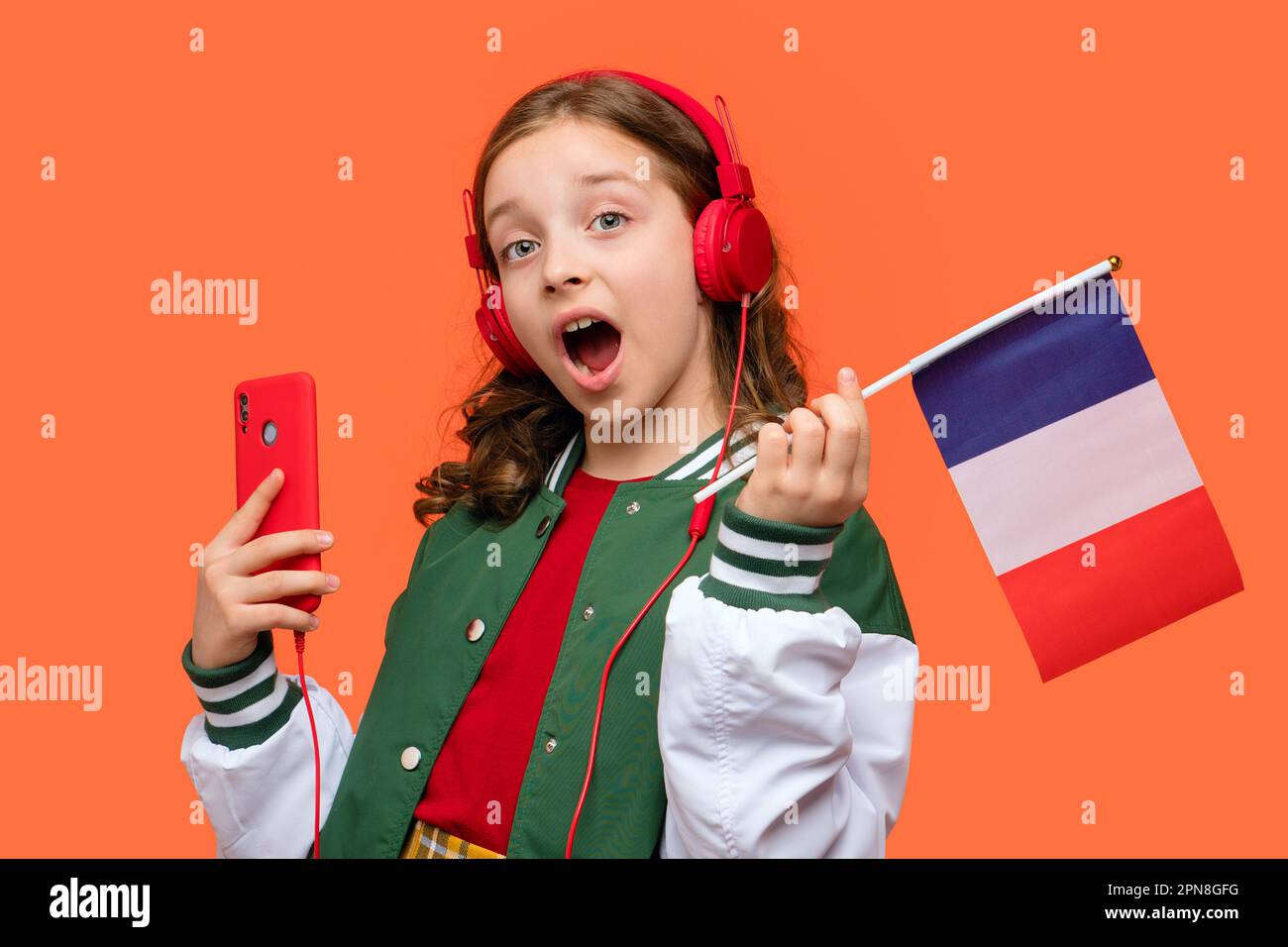 Teen school girl in casual clothes and headphones holds small national ...