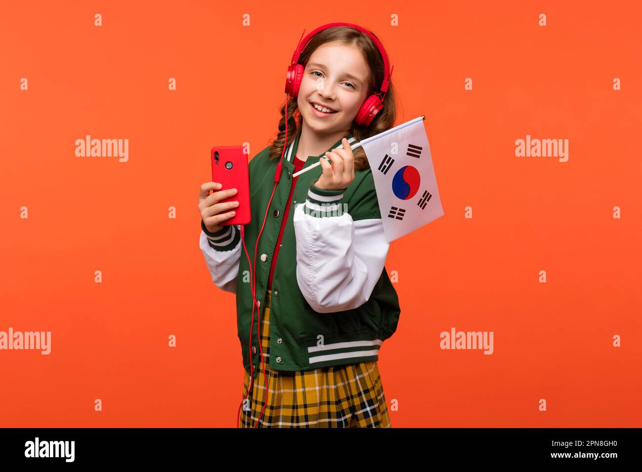 Teen school girl in casual clothes and headphones holds small national ...