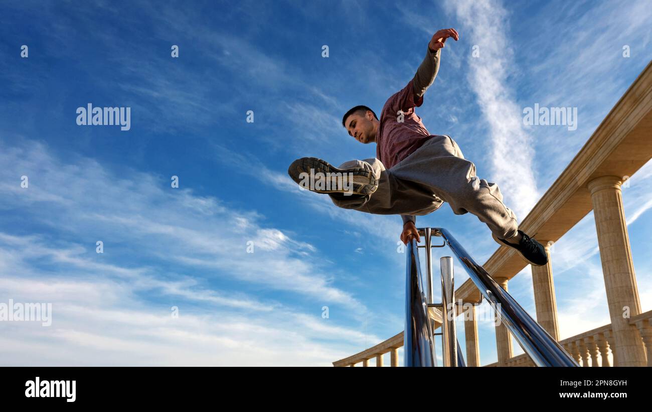 Sport man practicing parkour in urban space. Parkour athlete jumping on ...