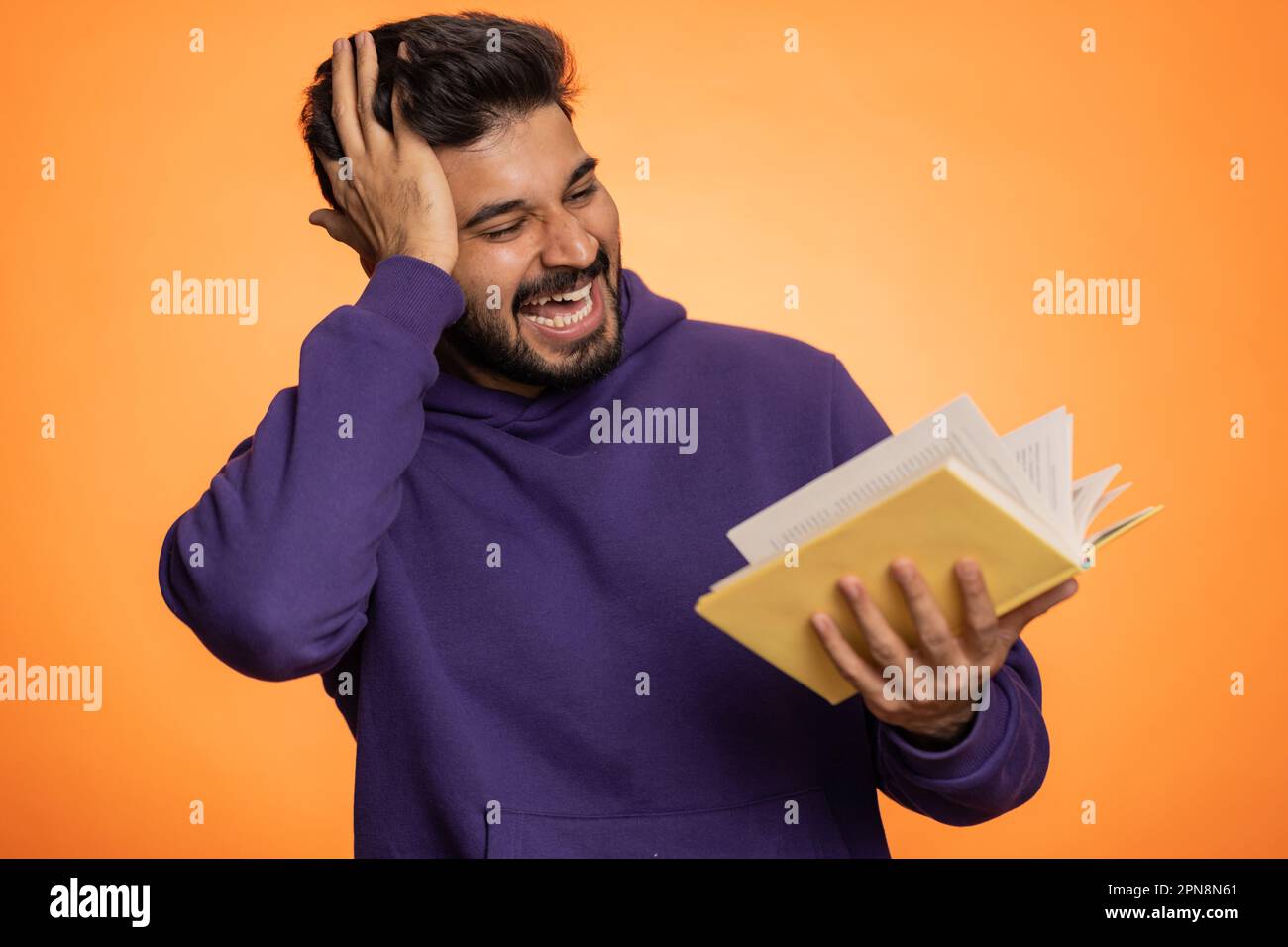 Happy indian man reading funny interesting fairytale story book ...