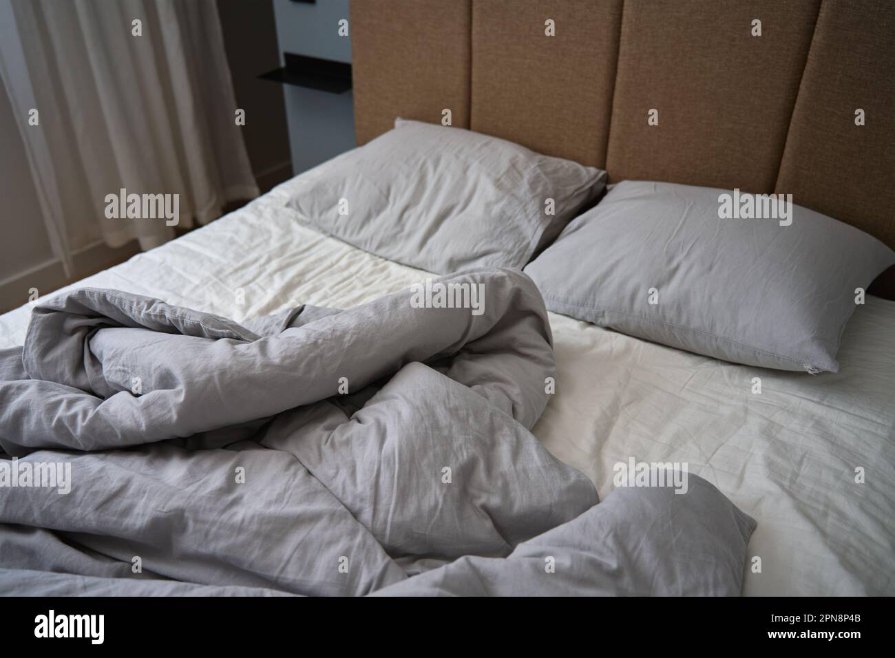 Unmade bed after sleeping. Crumpled bed with pillows, blanket and ...
